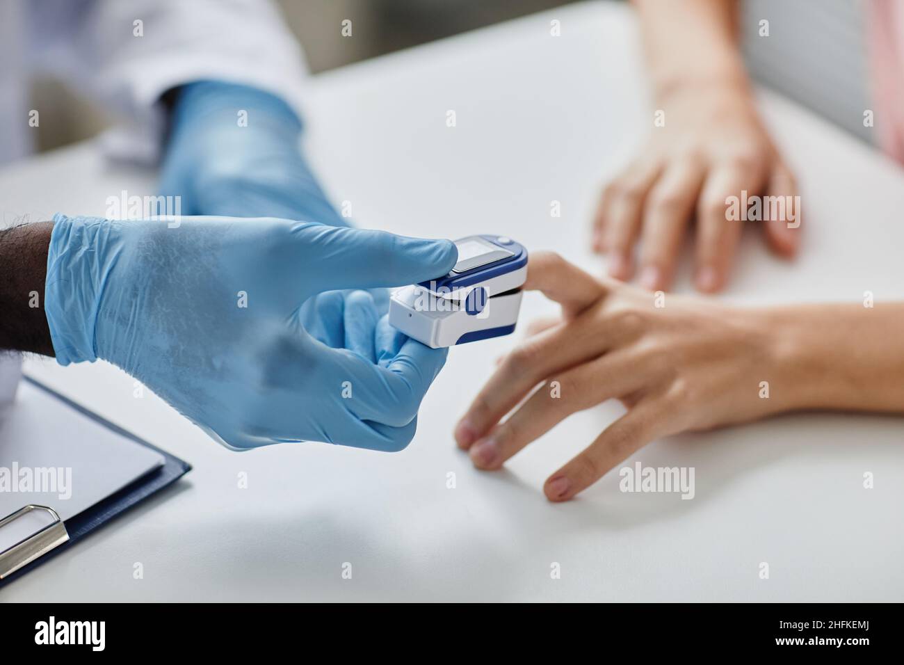 Close up of unrecognizable doctor measuring oxygen saturation of child ...