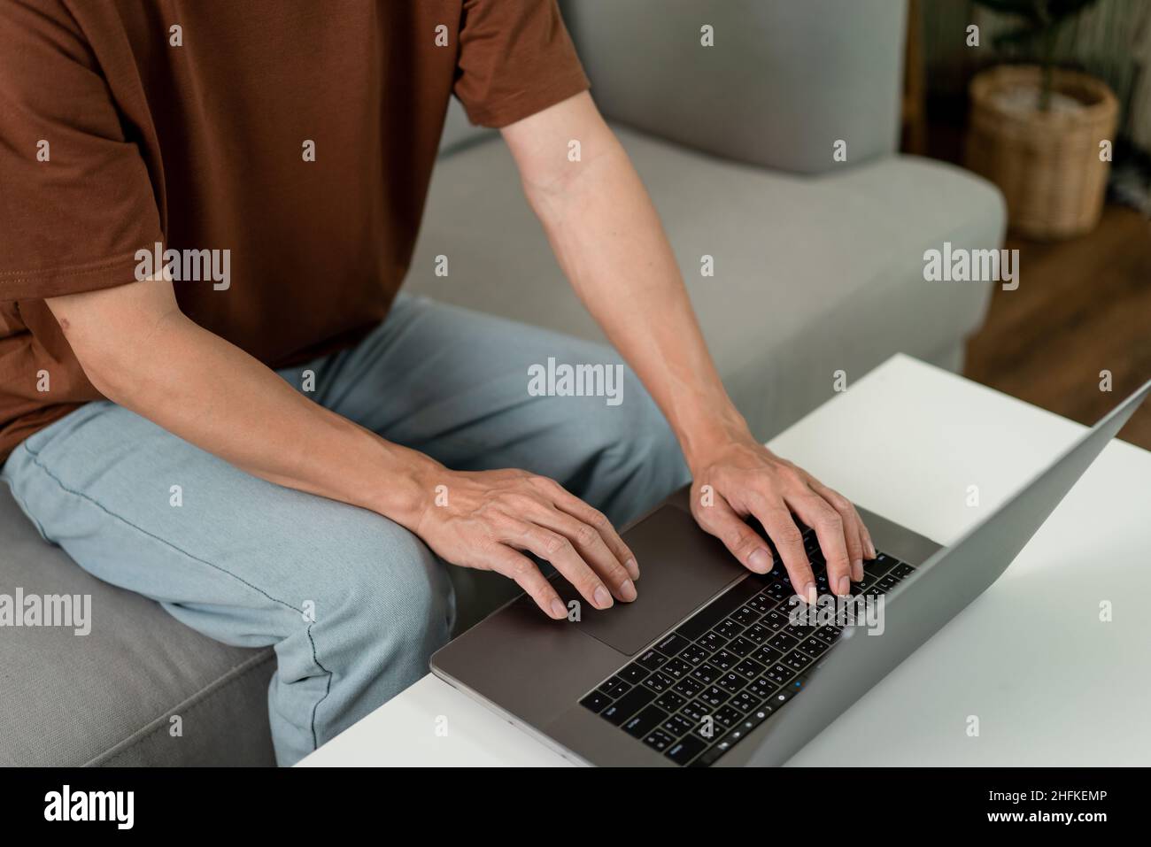 Technology Concept The man in brown T-shirt concentrating on typing ...