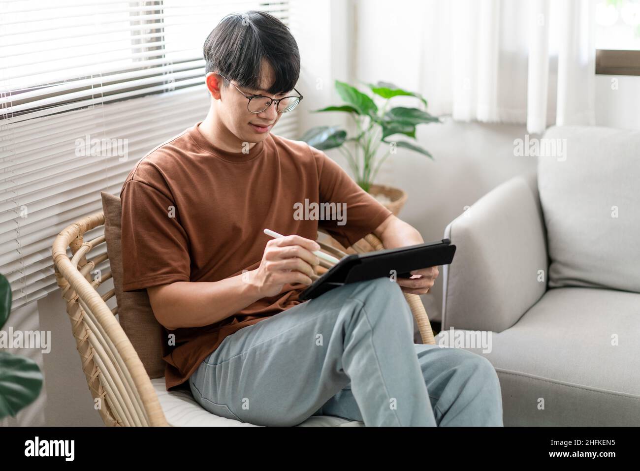 Technology Concept The young man who is sitting on the chair holding ...