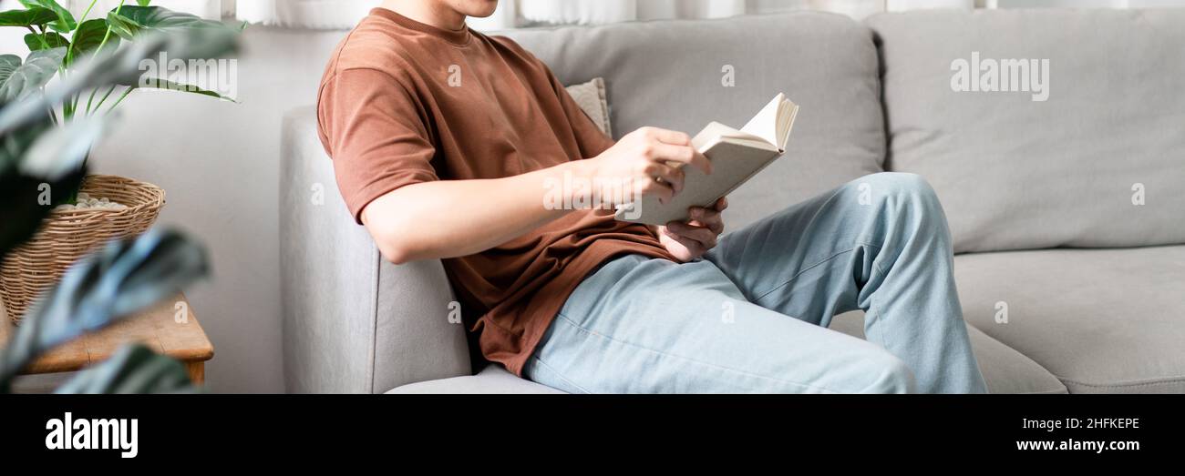 Technology Concept The male with his glasses sitting on the grey sofa ...