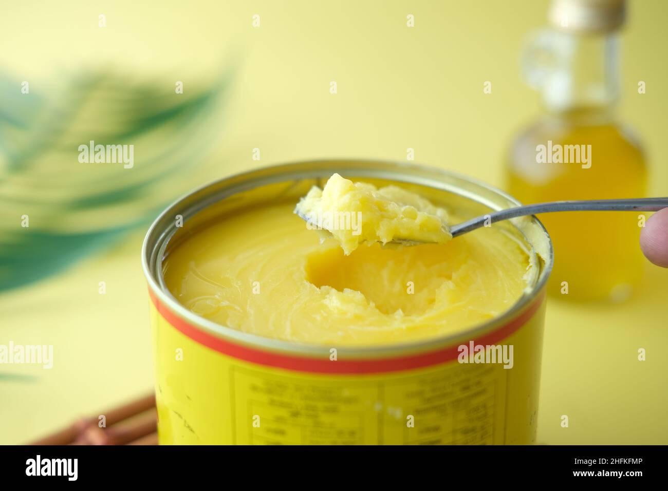 ghee in container on yellow background Stock Photo - Alamy