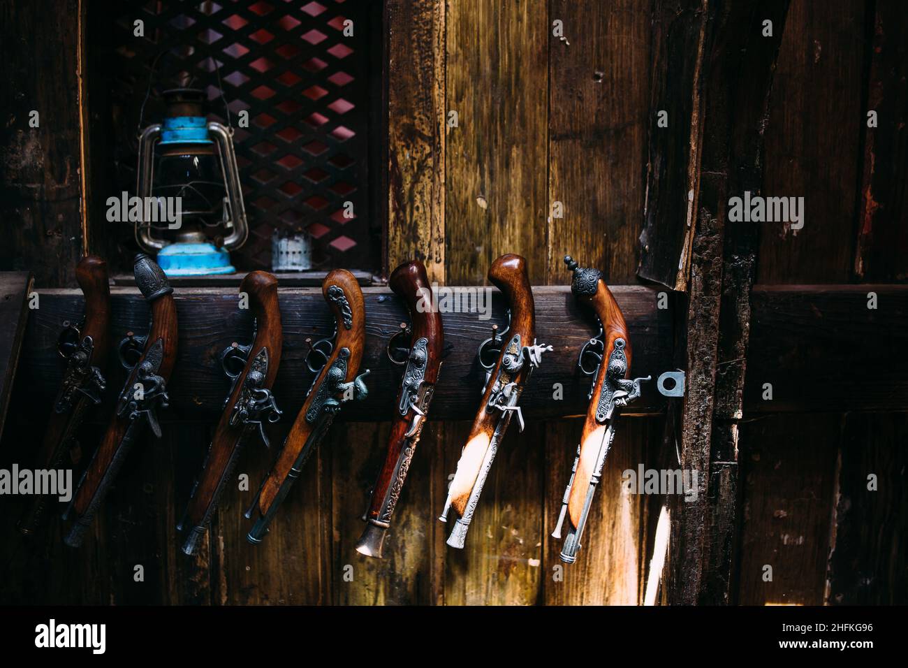 A set of old pistols on the shelf of a gift shop. Medieval weapons ...