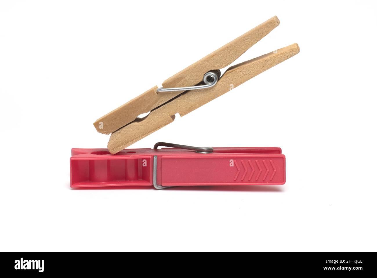 Close up of red plastic clothespin with metal spring with wooden one on ...