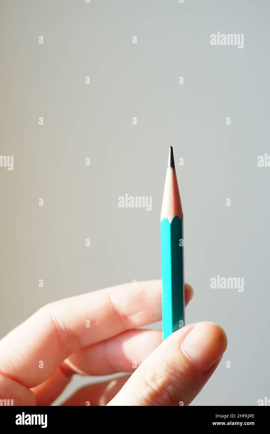 Graphite pencil in human hand. White wall background Stock Photo - Alamy