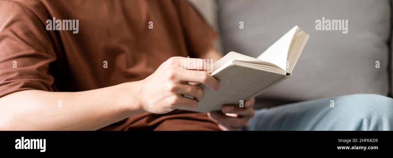 Technology Concept The male with his glasses sitting on the grey sofa ...