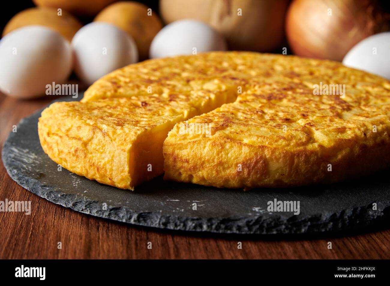 A closeup of a fresh tasty Spanish omelette and the ingredients on the ...