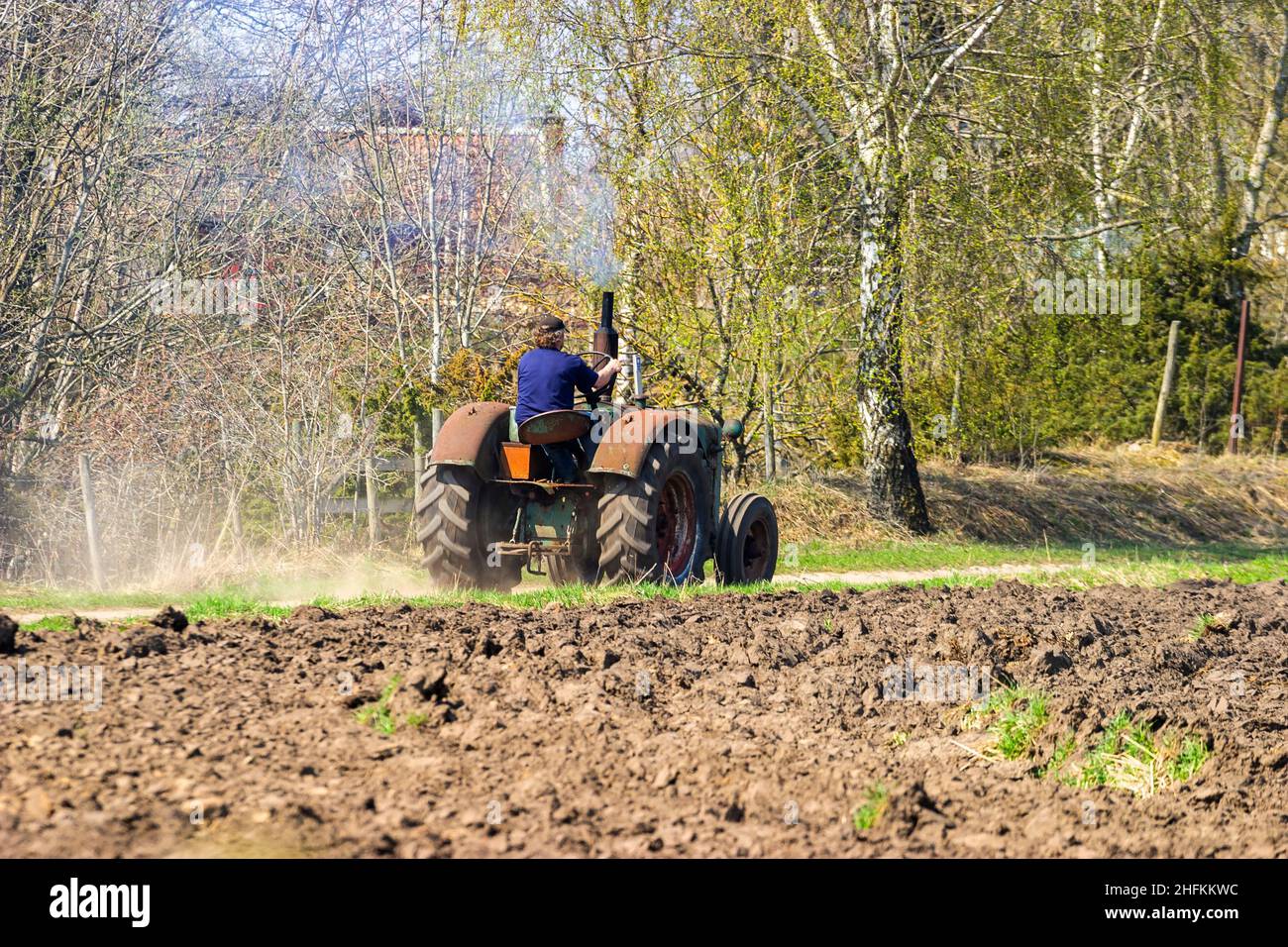 Old tractor driving on a road Stock Photo - Alamy