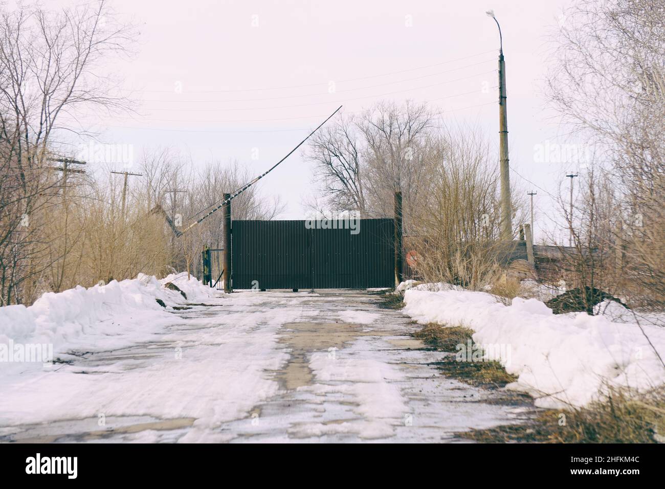 Iron gates and a barrier on an old abandoned road. Restricted area ...