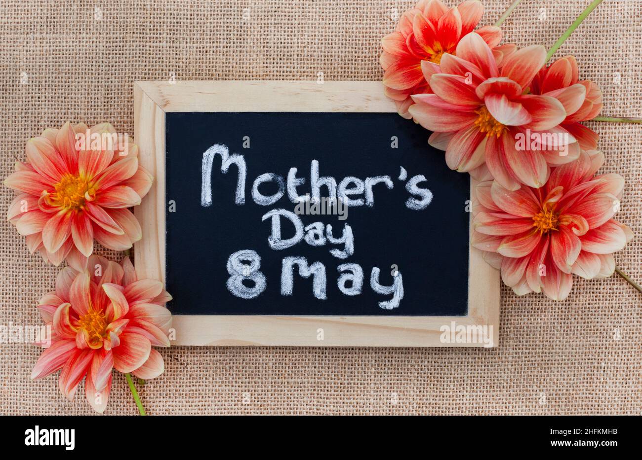 Mother’s Day 8 May written on chalk board with fresh flowers on a ...