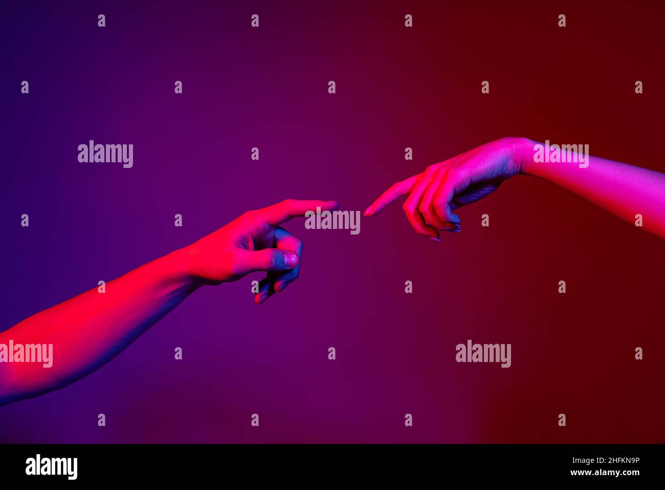 Two human hands trying to touch each other isolated on purple ...