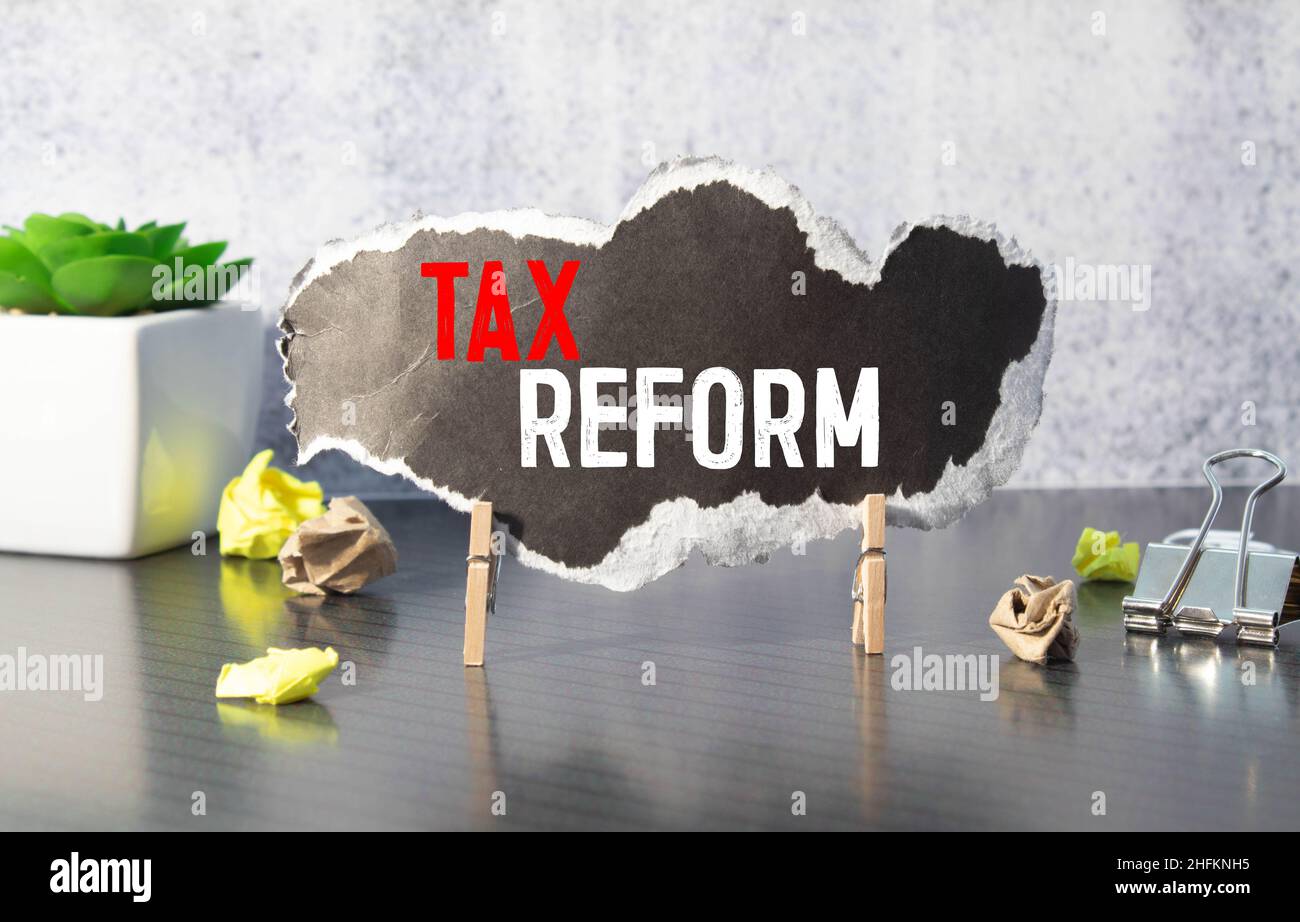 tax reform text on calculator screen with hundred dollar bill on 1040 ...