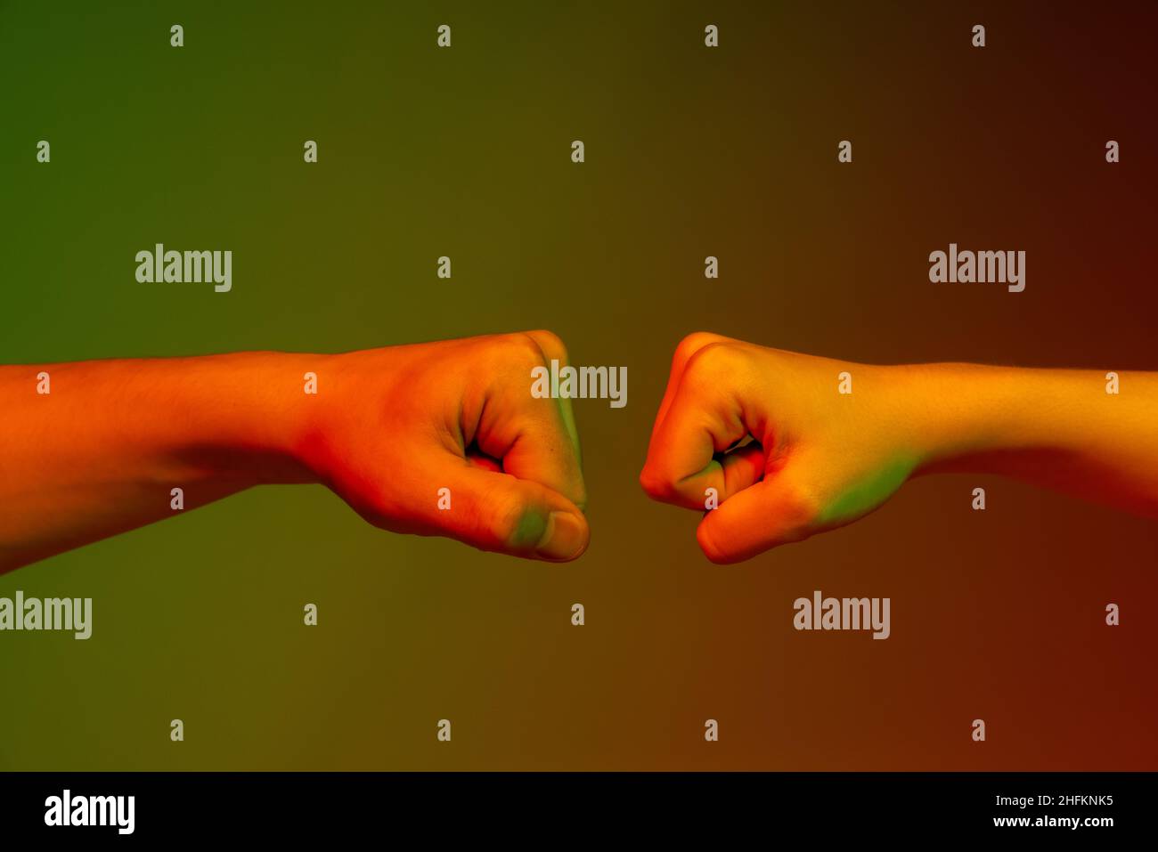 Authentic male and female hands clenched into fists gesturing on dark ...