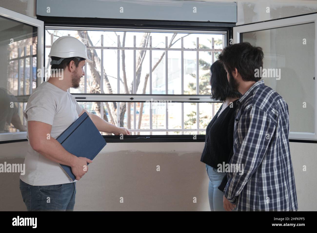 Architect shows the insect screen of the window of a new apartment to a ...