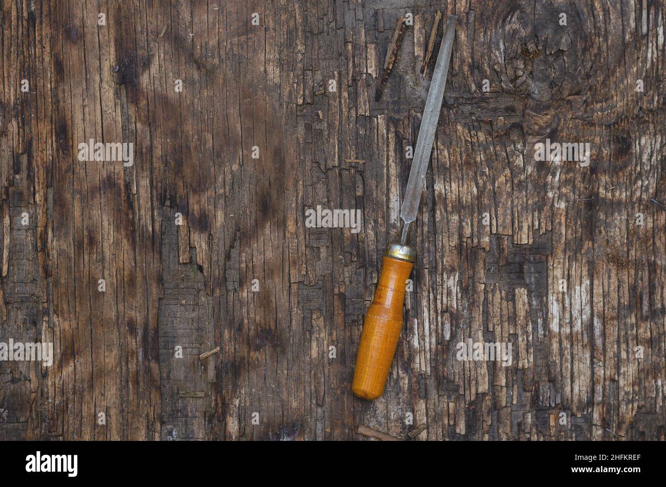 Metal file on a wooden background. An old triangular file with a wooden ...