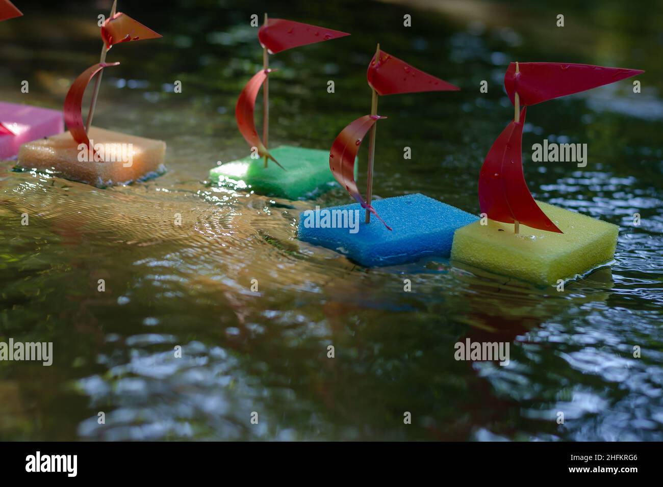 Children's ships in the summer river. Homemade boats from kitchen ...