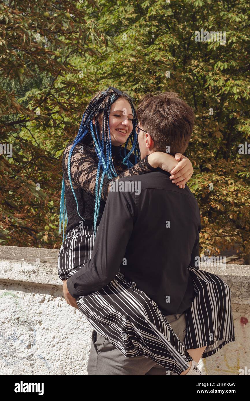 The young adult carries or holds his beloved in his arms. Her legs are ...