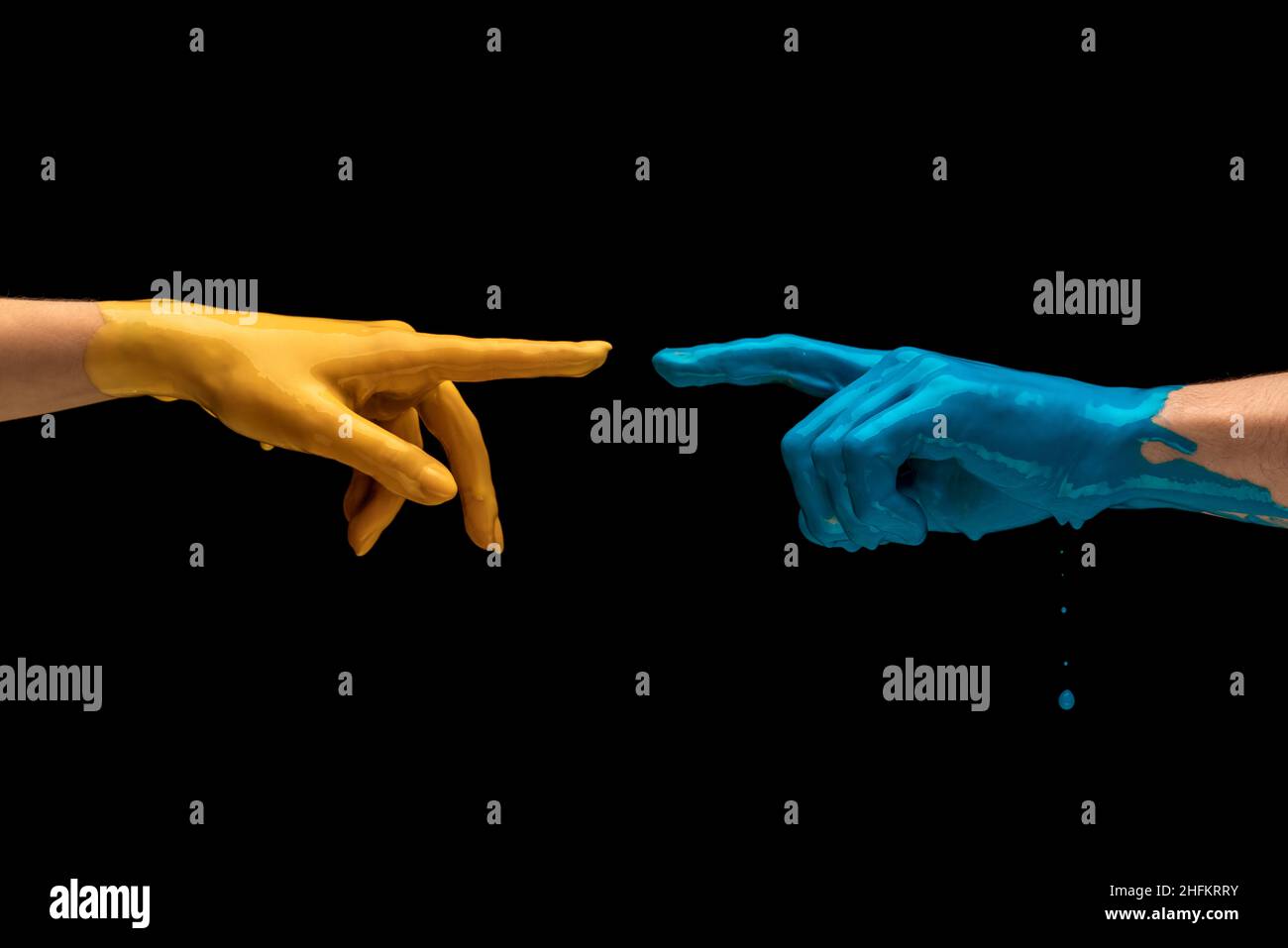 Blue and yellow painted hands trying to touch each other isolated on ...