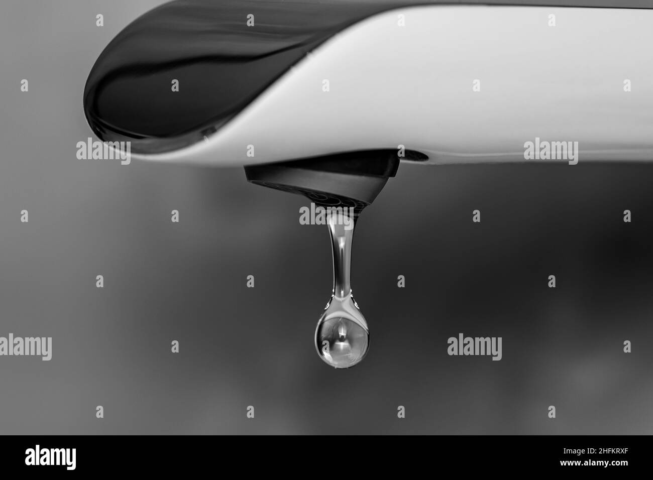 Crystal clear water drop falling from the faucet. Black and white ...