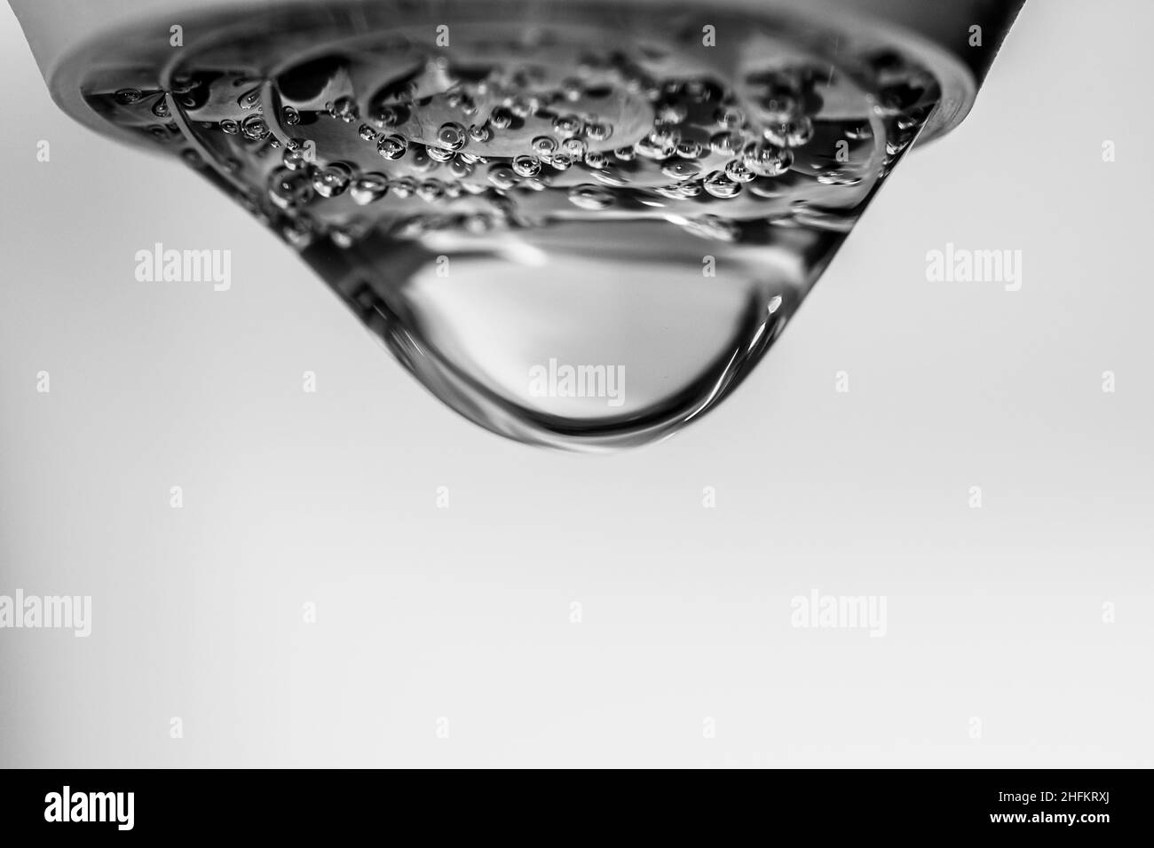 Big crystal clear water drop falling from the faucet. Black and white ...