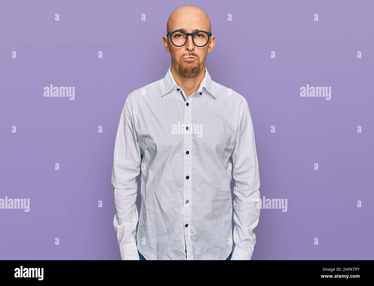 Bald man with beard wearing business shirt and glasses depressed and ...