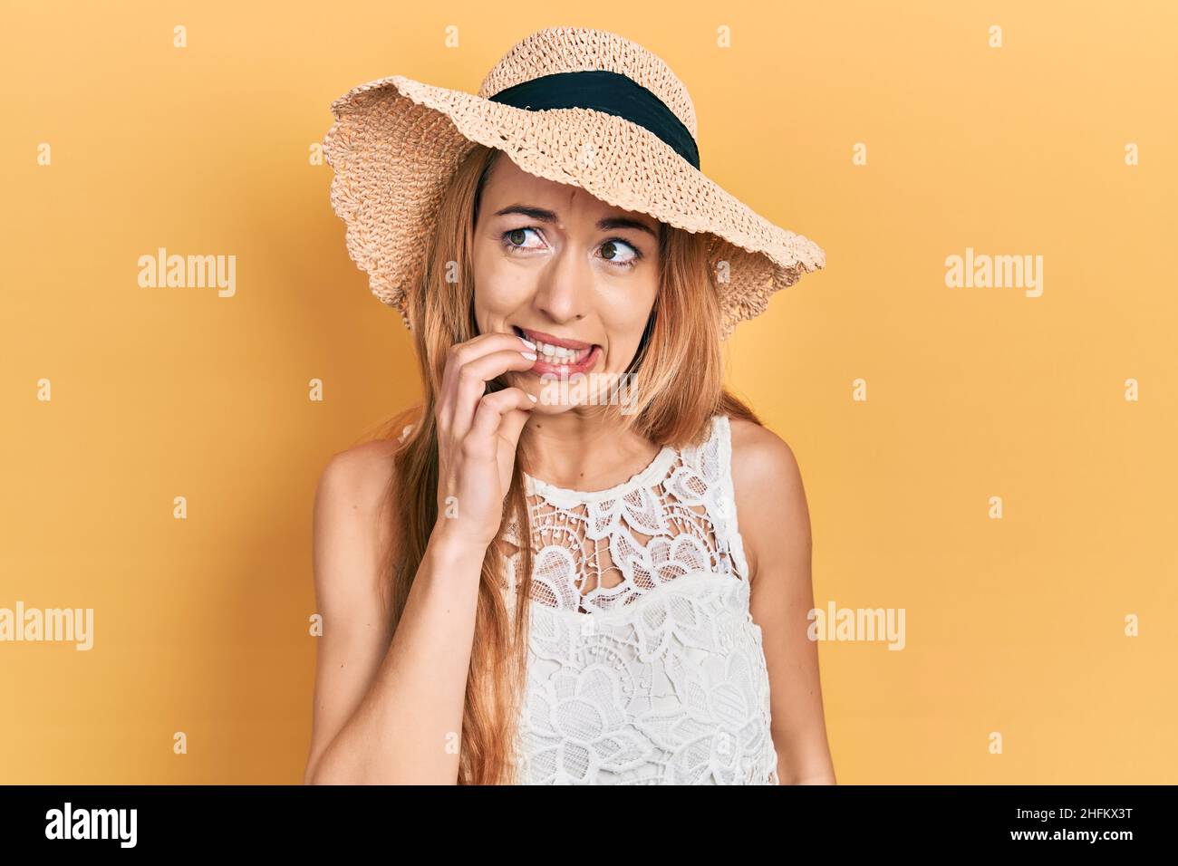 Young caucasian woman wearing summer hat looking stressed and nervous ...