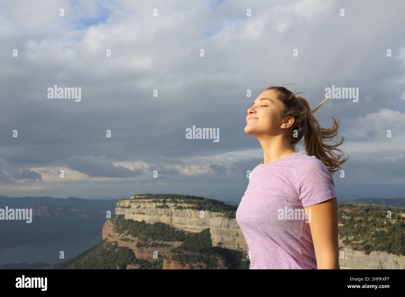 Happy woman breathing fresh air a windy day in nature Stock Photo - Alamy