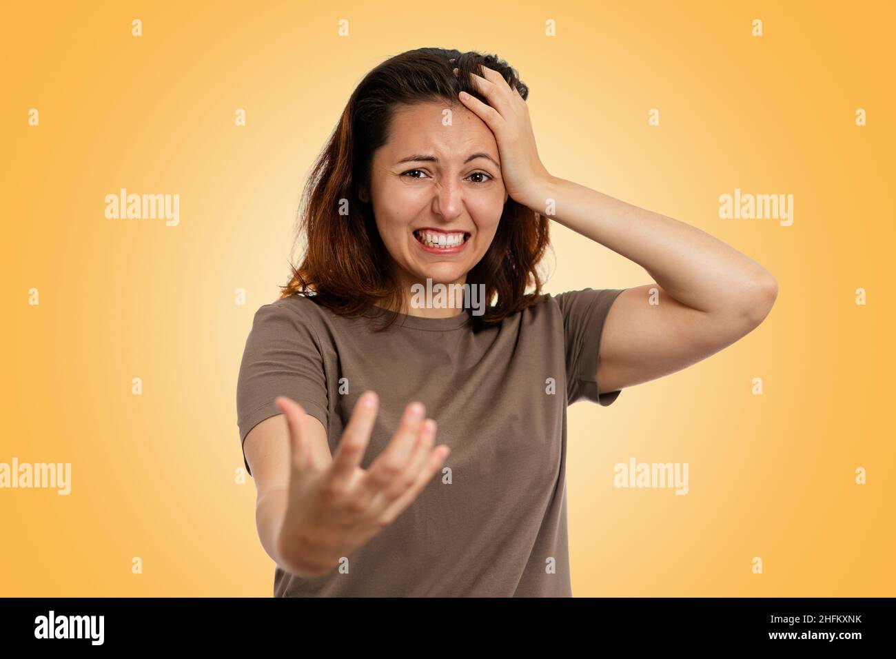 Portrait of an angry young Caucasian woman with tense hands, clutching ...