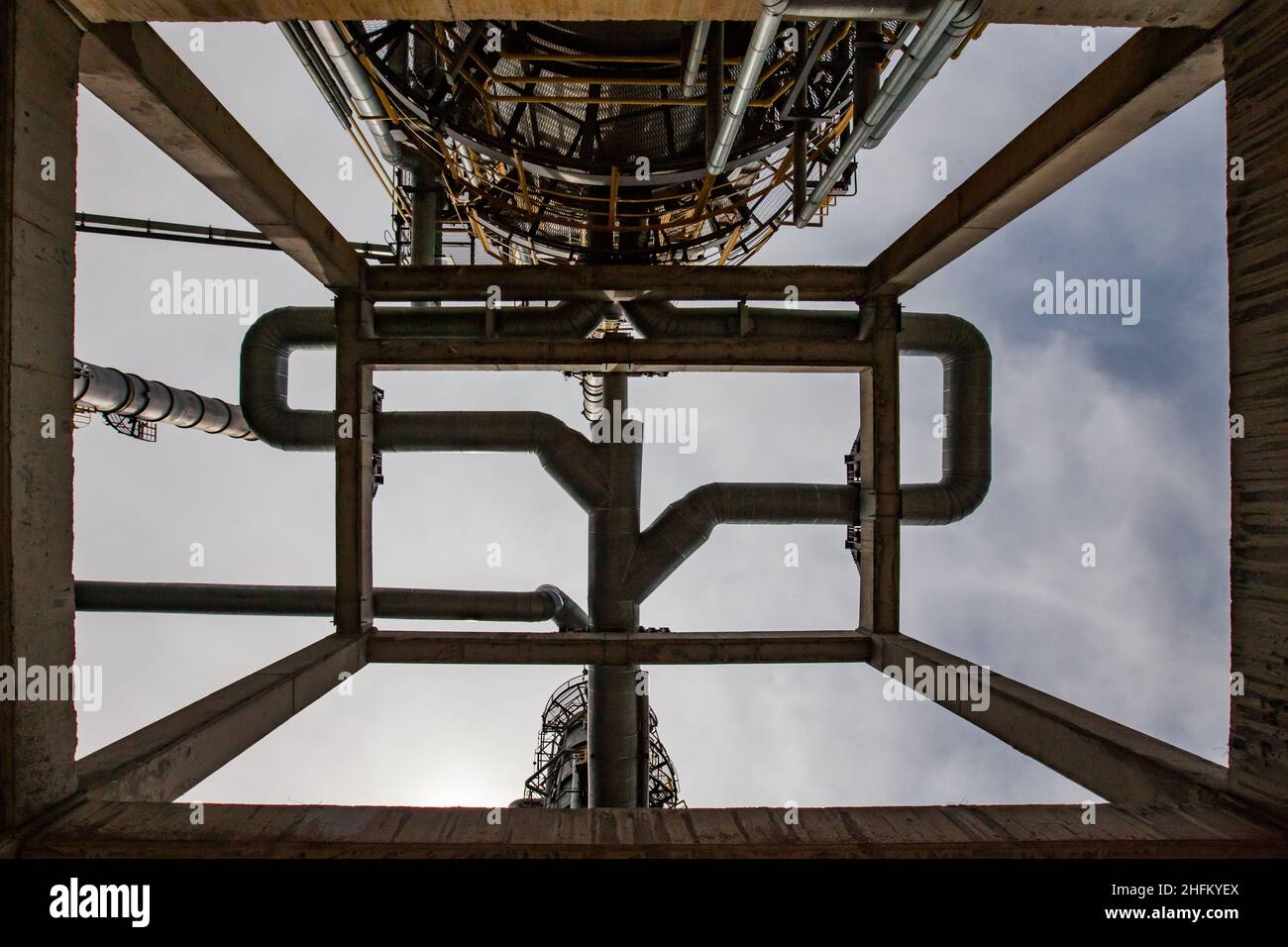 Concrete frame and pipes on Oil refinery plant. Blue sky and sun ...