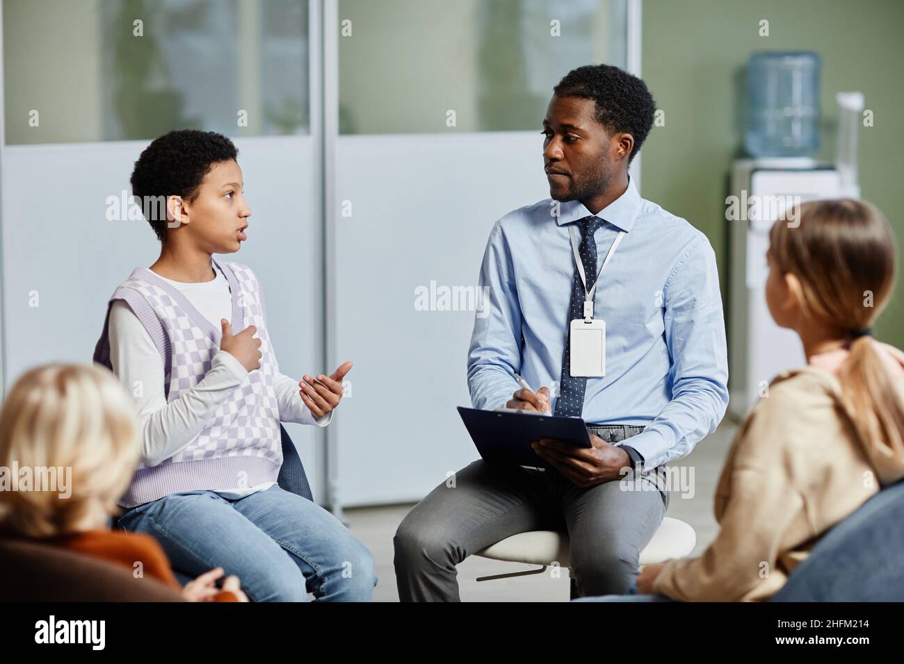 Portrait of young African-American therapist leading support group for ...