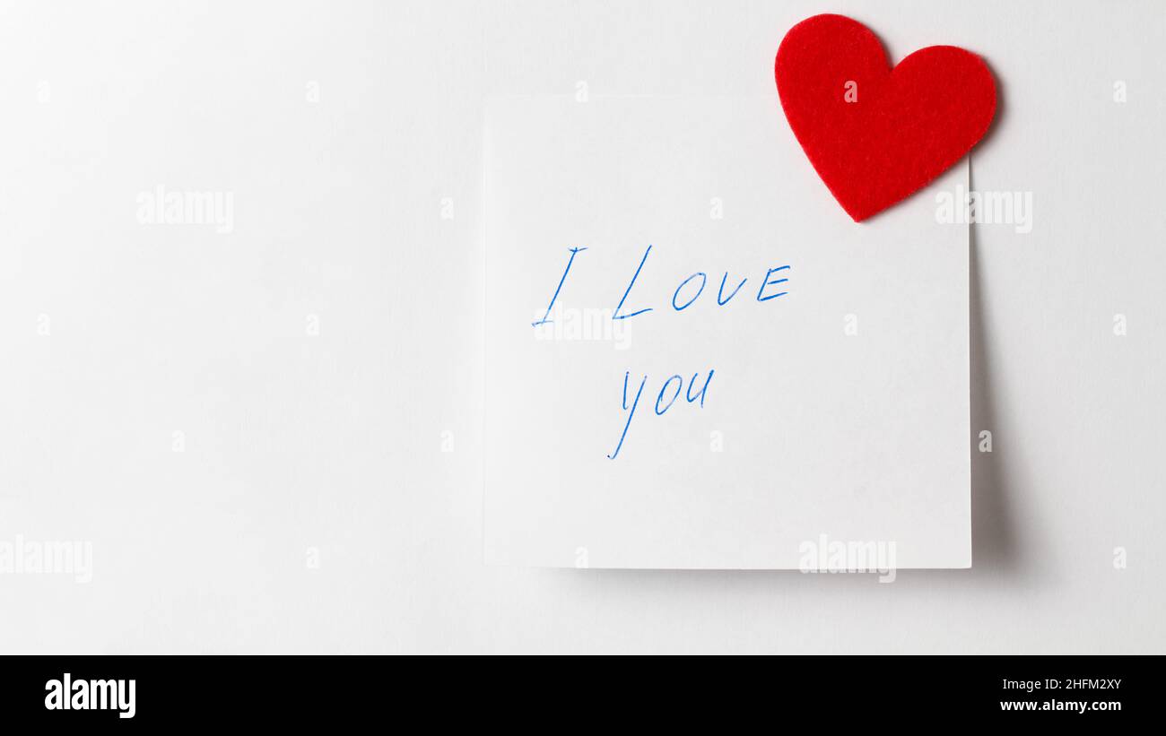 A close up of a white sticky note with the word I Love You with red heart. Valentine's Day ...