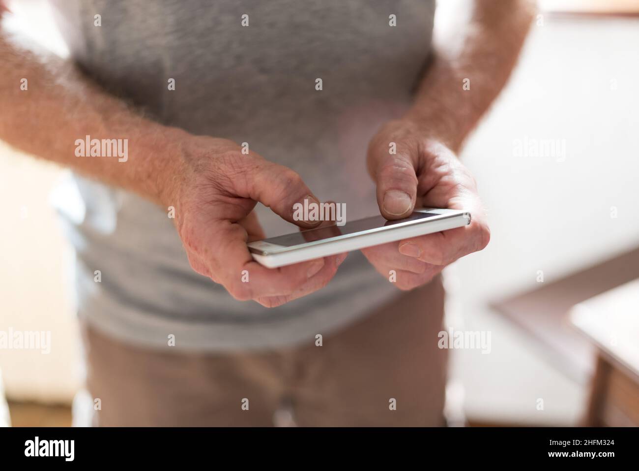 Man standing using his smartphone Stock Photo - Alamy