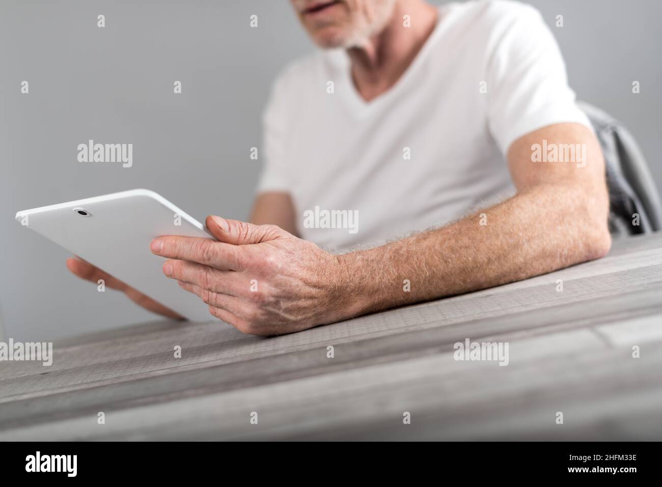 Man sitting using a tablet Stock Photo - Alamy