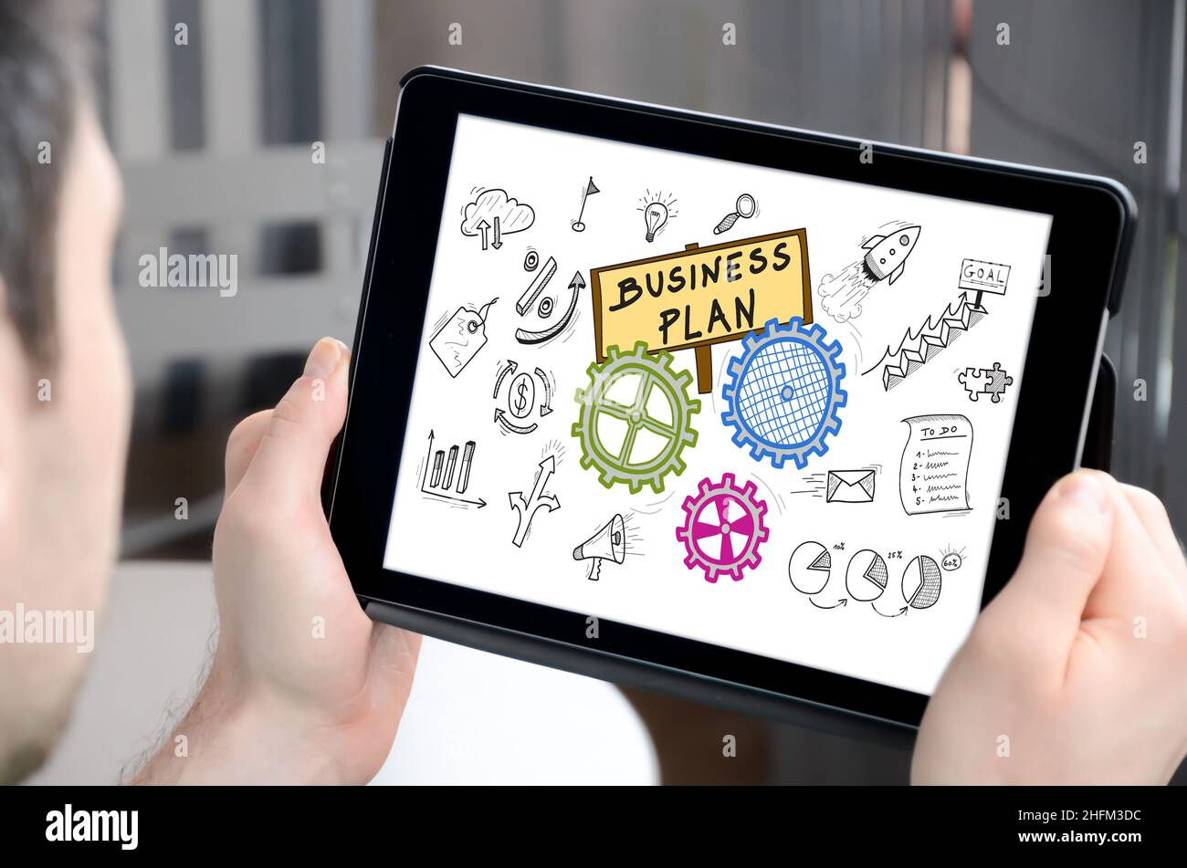 Man holding a tablet showing business plan concept Stock Photo - Alamy