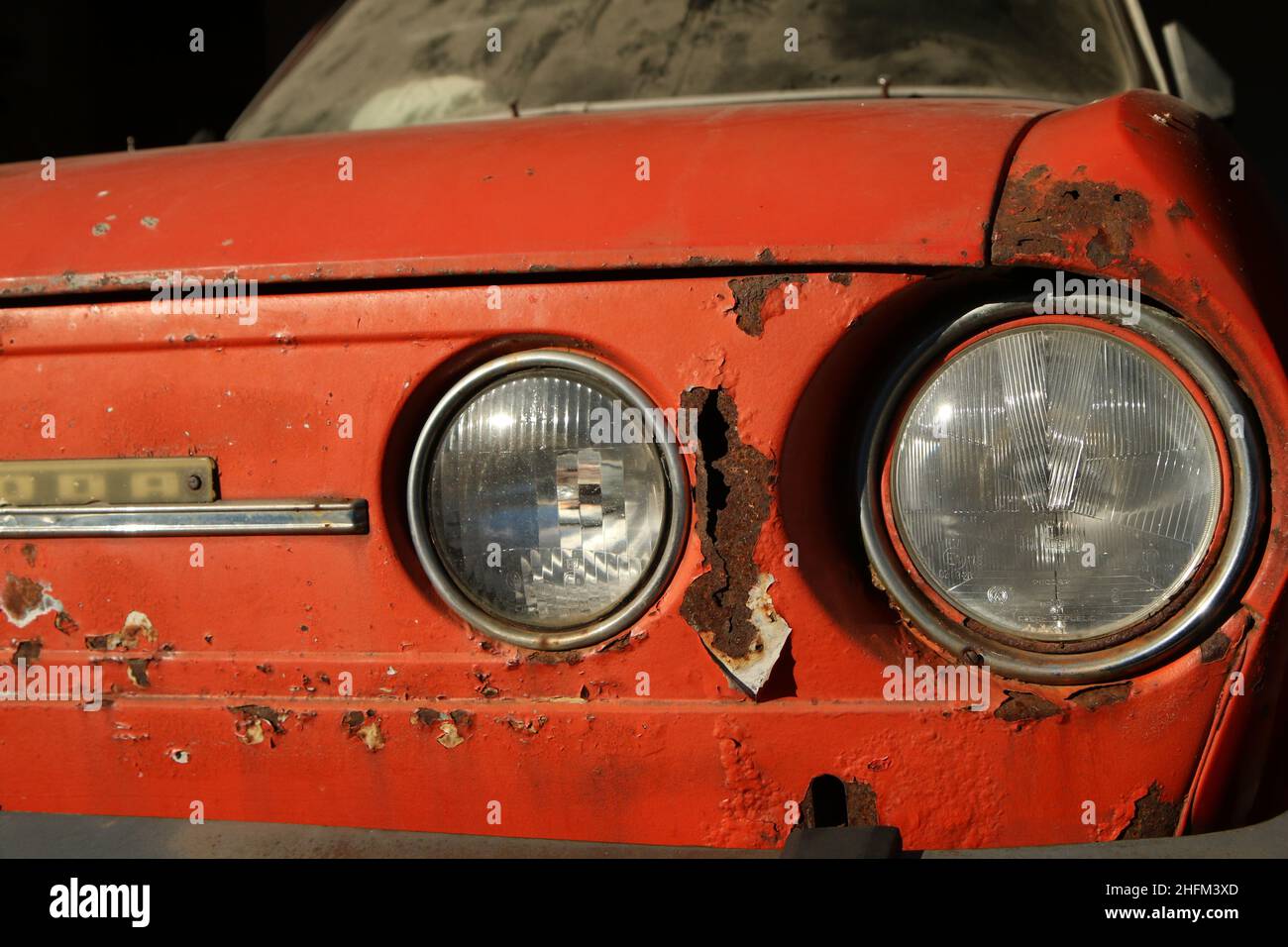 The detail of the front part of a neglected classic car. The metal ...