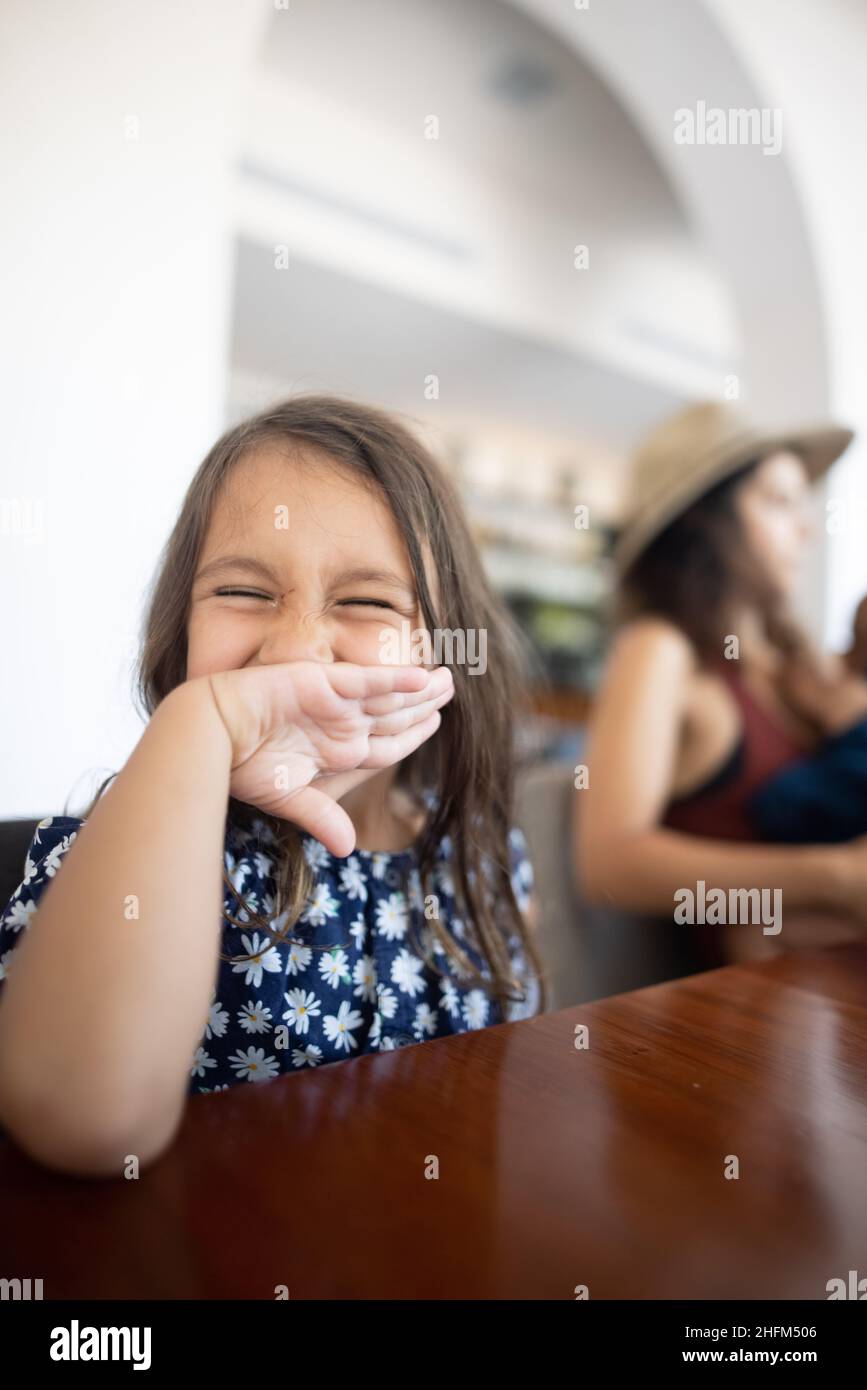 Cute little girl covering her smile with the back of her hand Stock ...