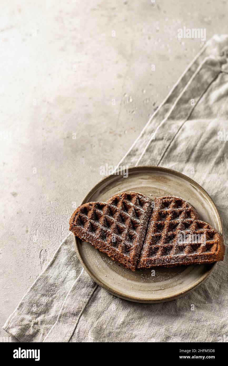 Two chocolate waffles in the shape of a heart in ceramic plate on ...