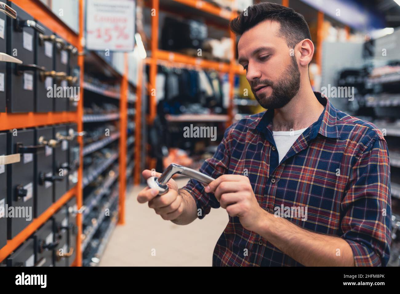 a man in a hardware store chooses a handle for a door Stock Photo - Alamy