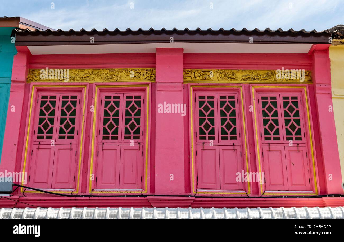 wooden shutter on a building in thailand painted bright pink with ...
