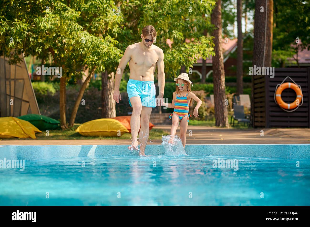A young man in blue swim shorts at the swimming pool Stock Photo - Alamy