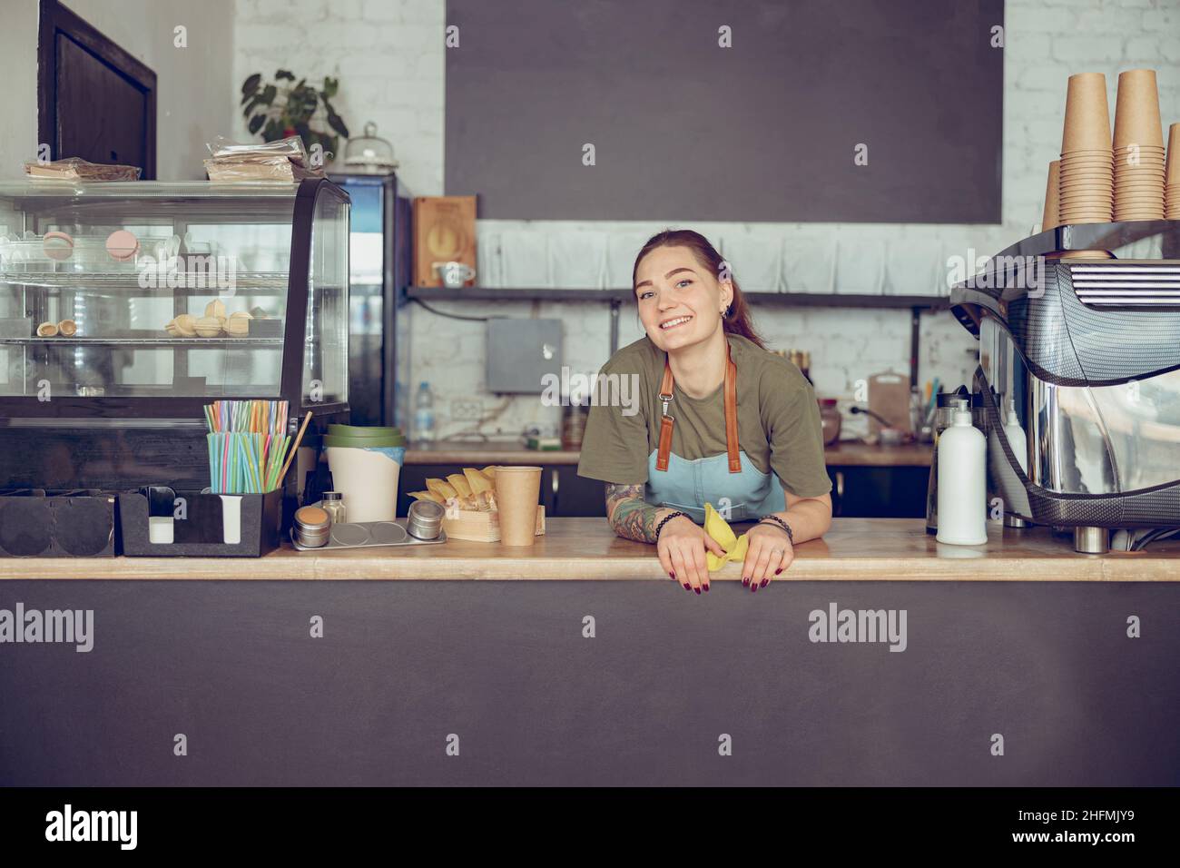 Joyful female barista standing behind counter in cafe Stock Photo - Alamy