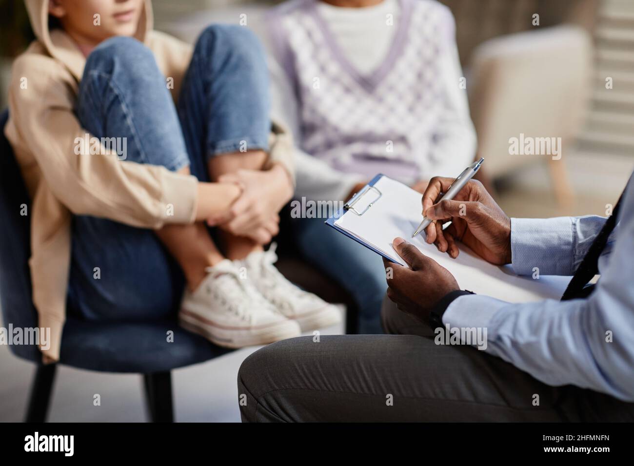 Close up of African-American psychologist taking notes on clipboard in ...