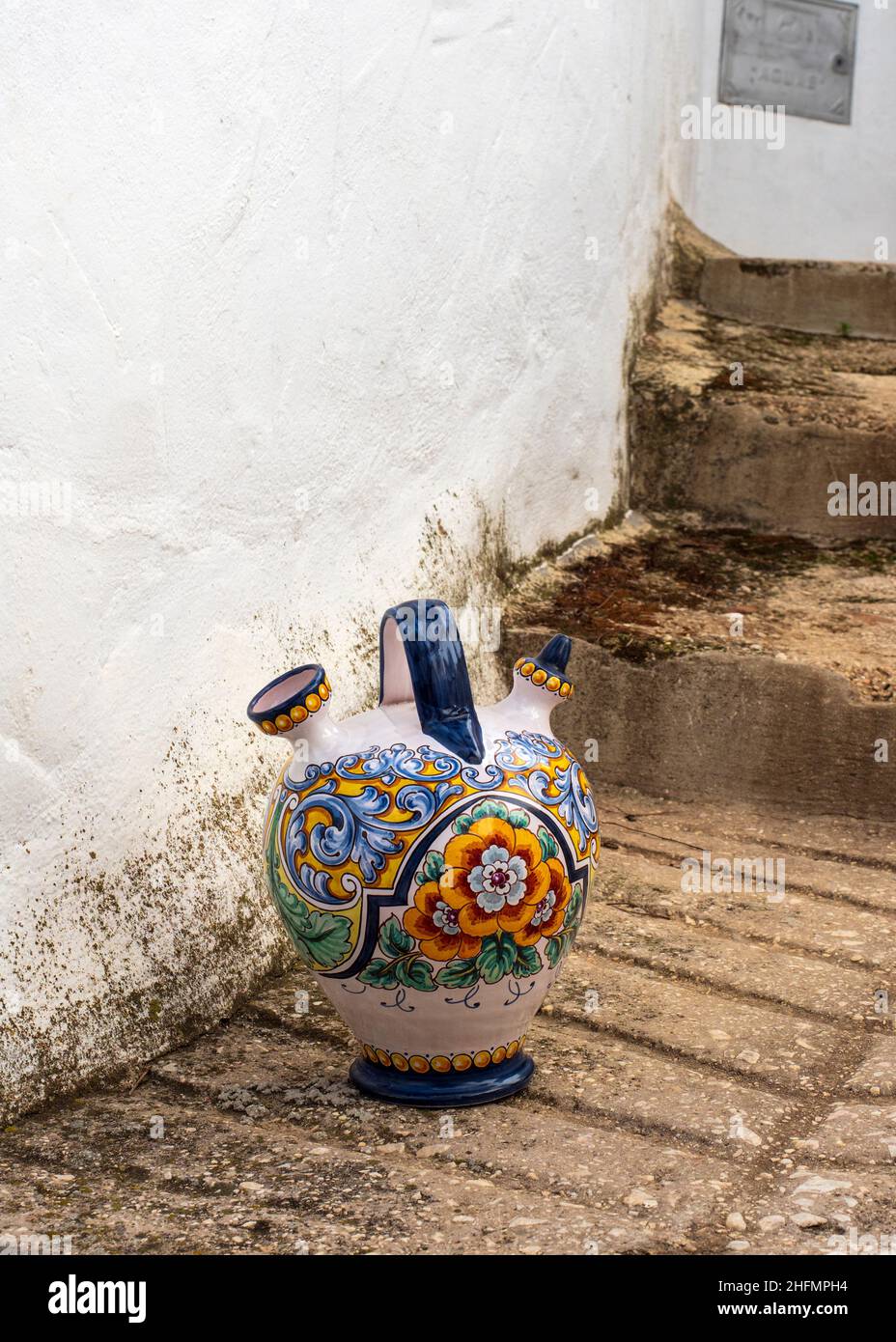 A ceramic botijo (earthenware jug) on the ground in a street in ...