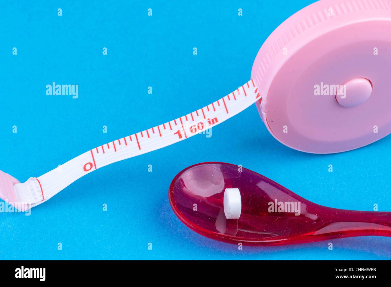 homeopathic tablet with red spoon and measuring tape Stock Photo - Alamy