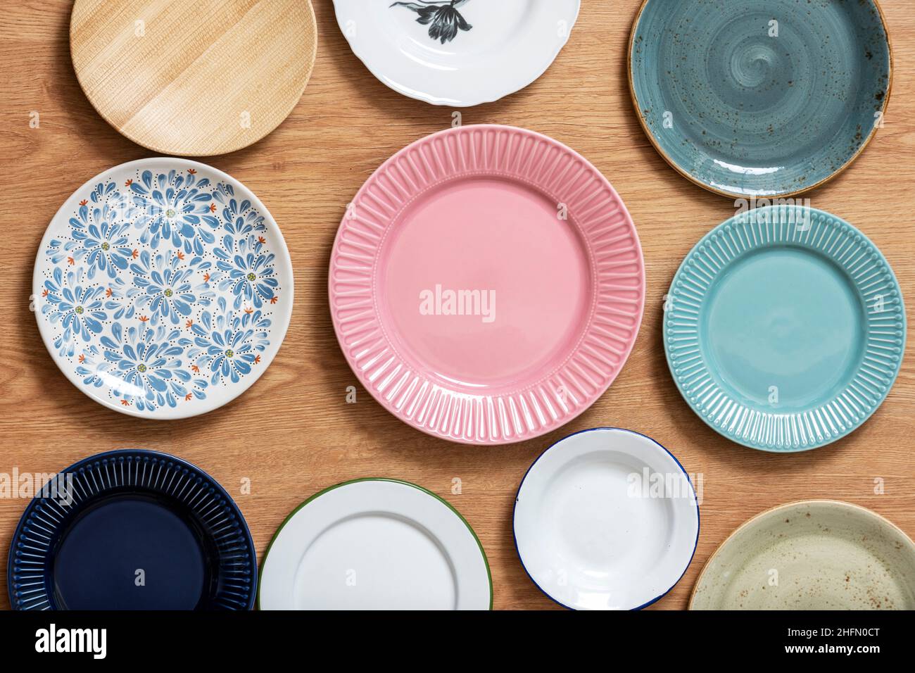 Assorted colored porcelain plates on oak wood Stock Photo - Alamy