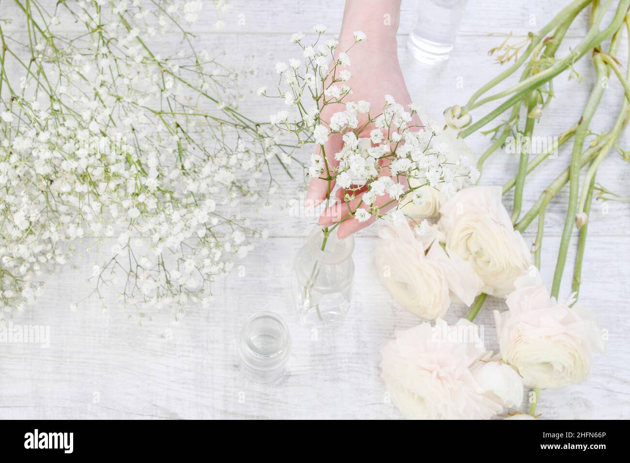 Florist at work: woman making decorations with ranunculus flowers and ...