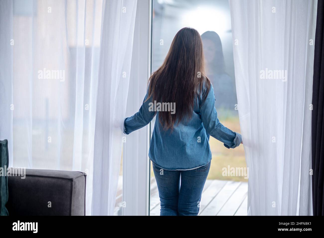 Back view of woman standing near glass door Stock Photo - Alamy