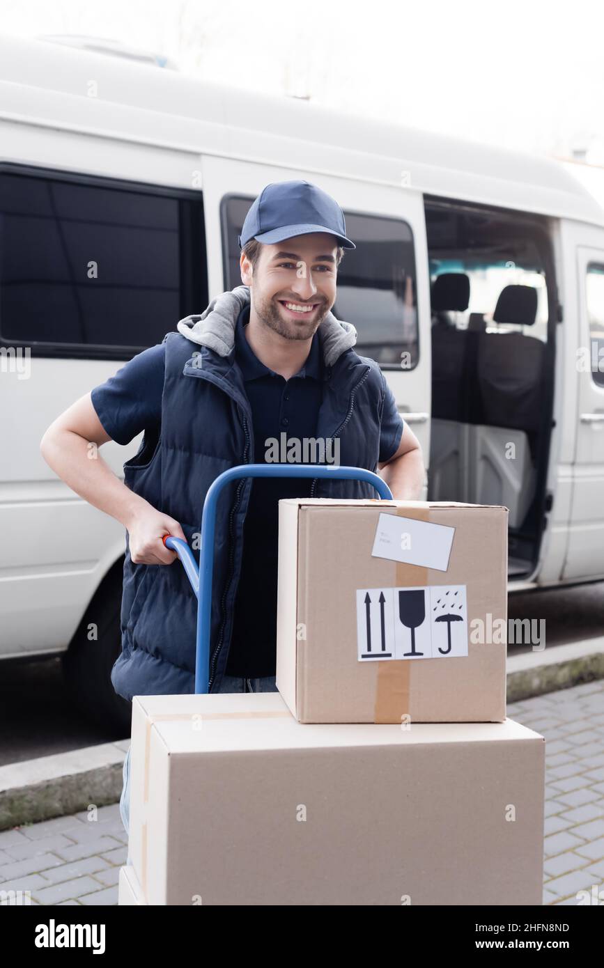 Cheerful delivery man holding hi-res stock photography and images - Alamy