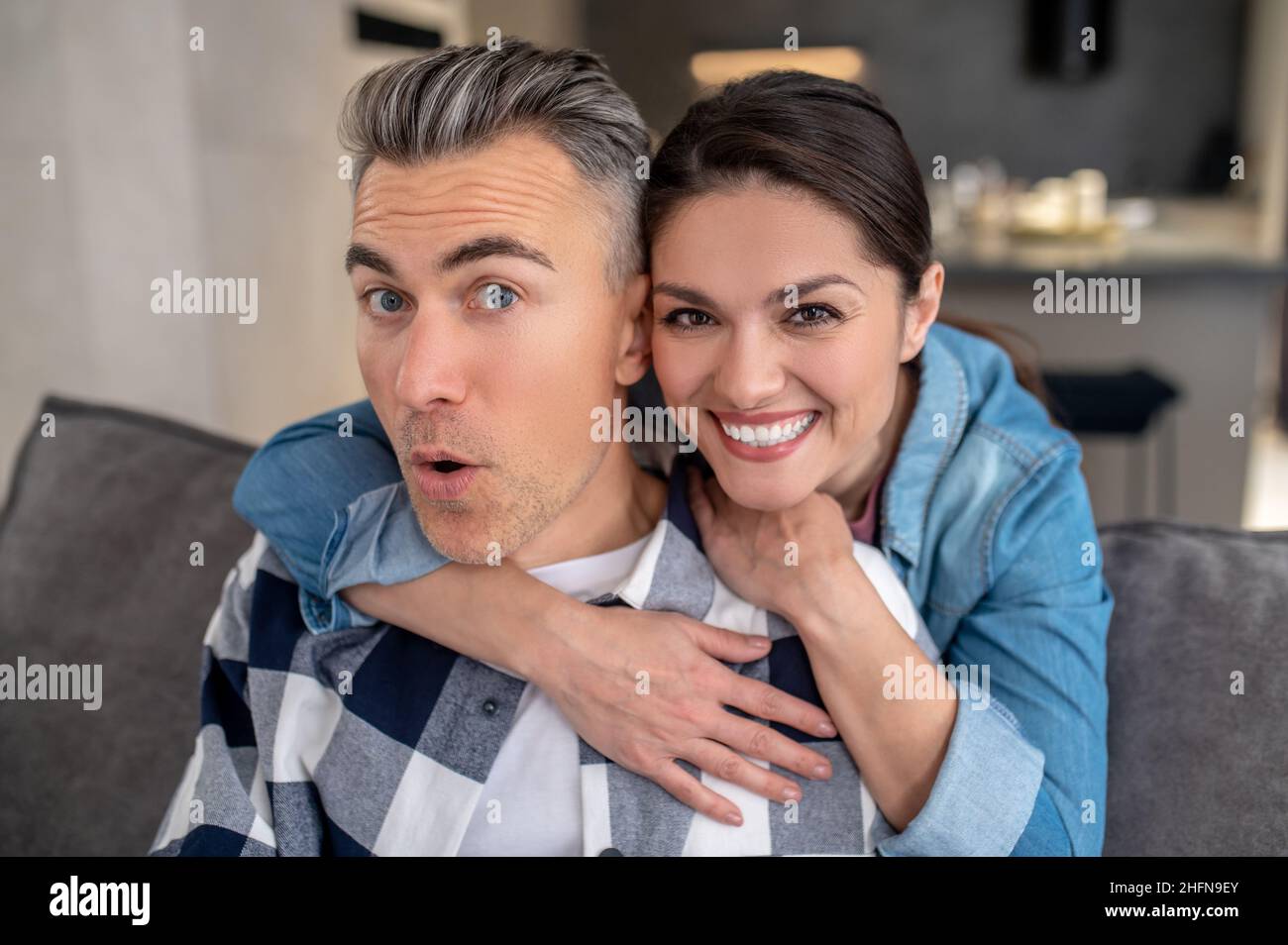 Woman hugging cheerful man looking at camera Stock Photo - Alamy