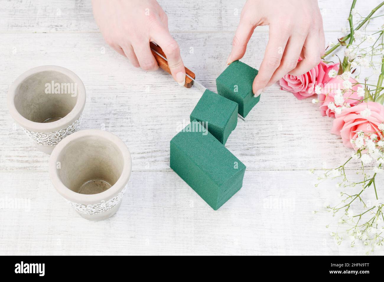 Florist at work: woman making decorations with pink roses and white ...