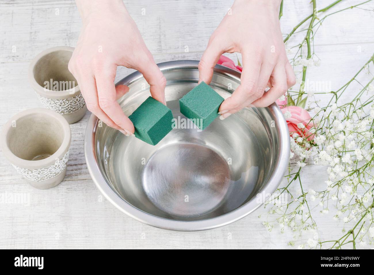 Florist at work: woman making decorations with pink roses and white ...